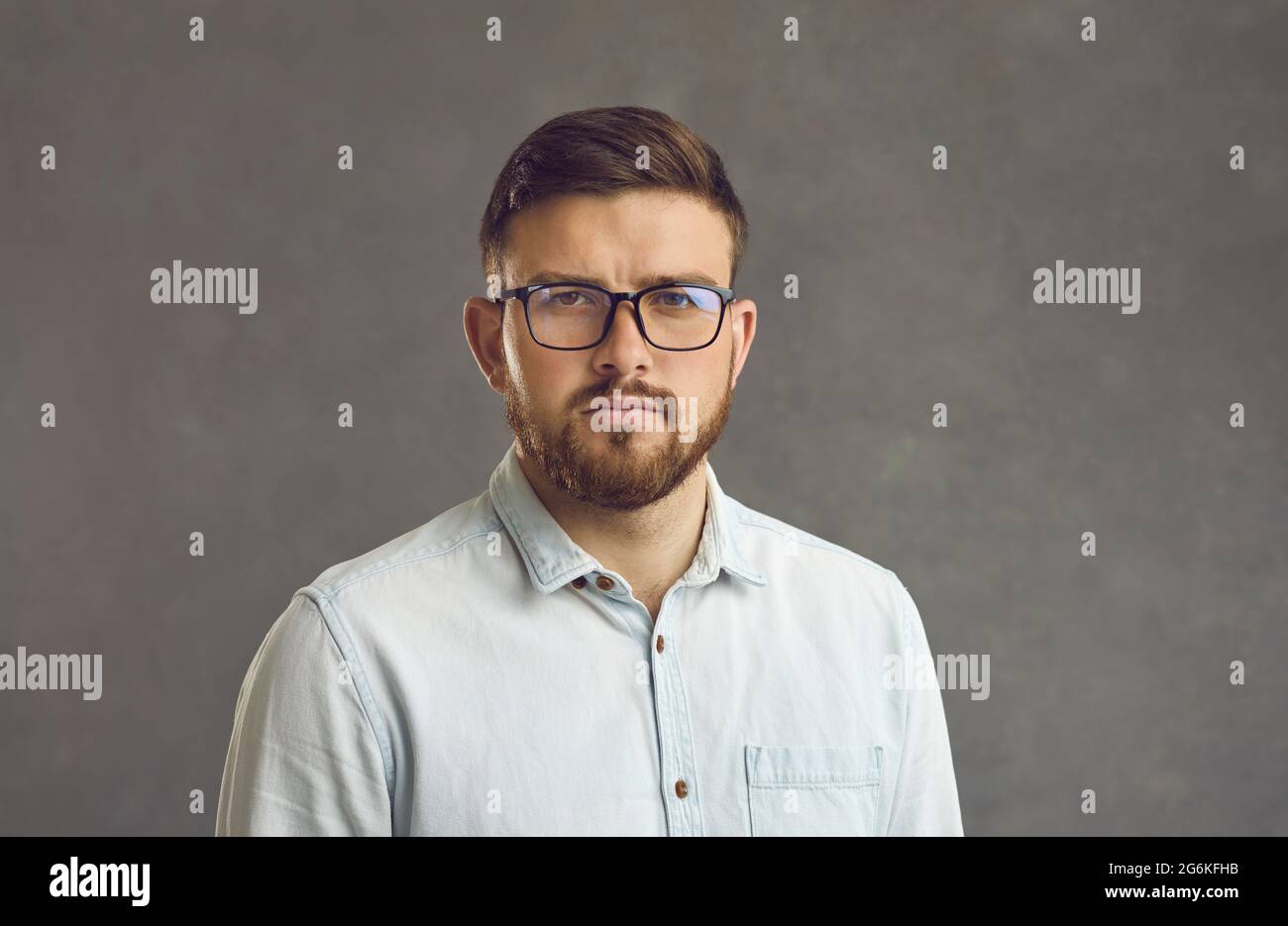 Close up studio portrait of millennial man with serious facial ...
