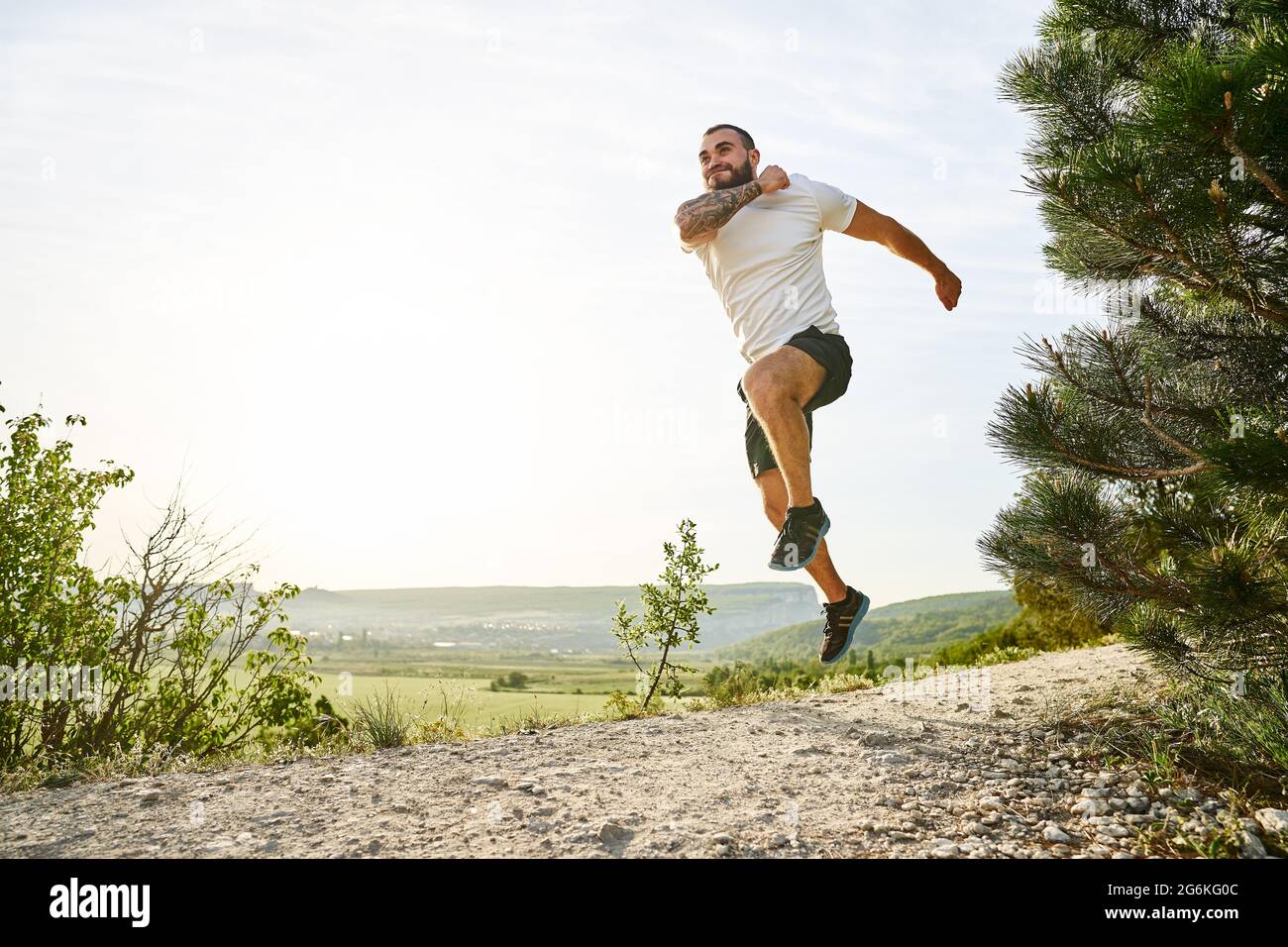 Young muscular male athlete running up the hill Stock Photo - Alamy