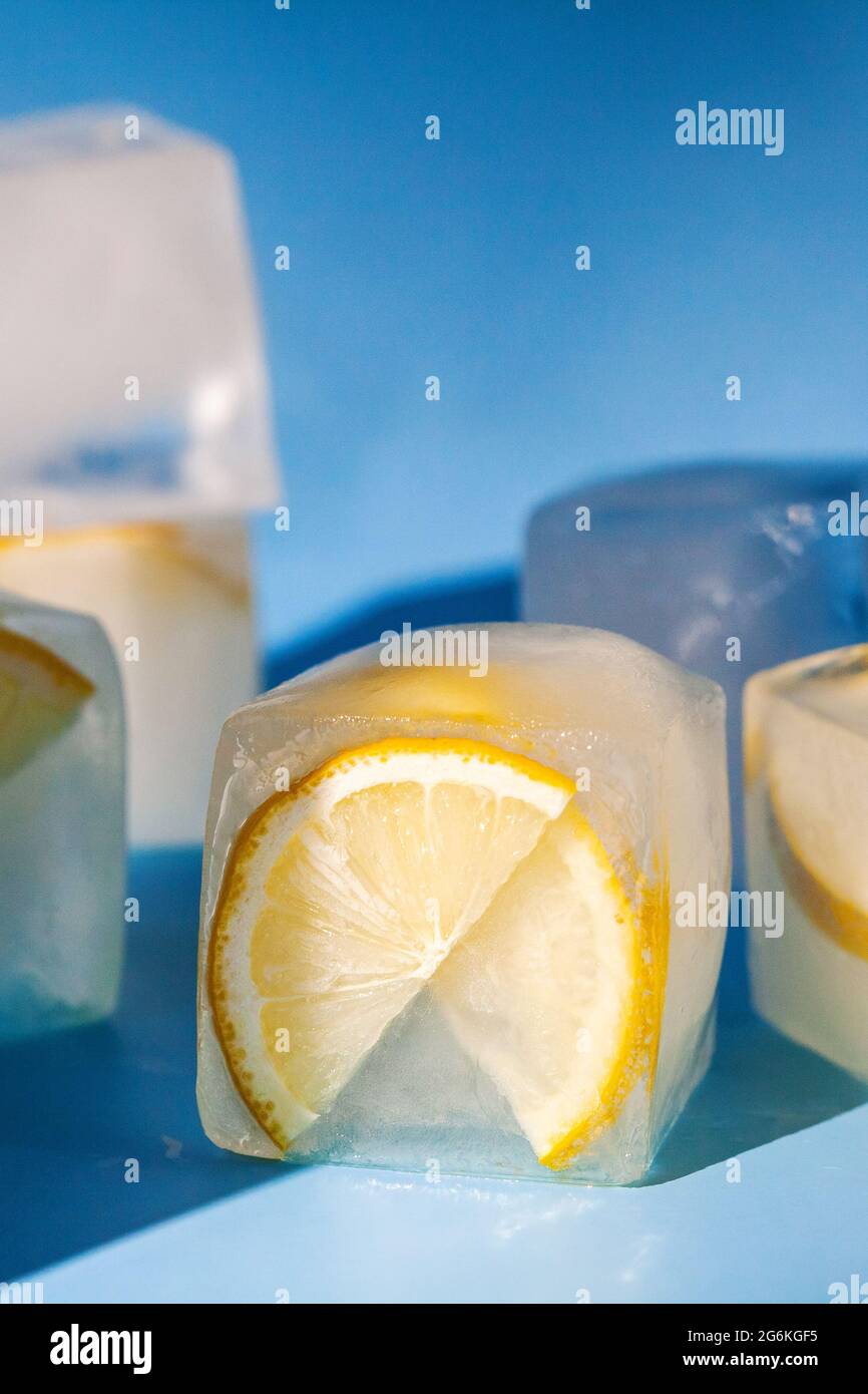 Modern composition of the frozen slices of lemon and ice cubes on a blue background Stock Photo ...