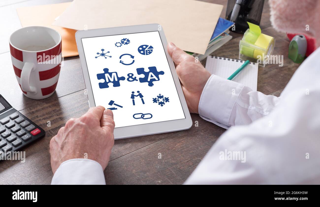 M&a concept shown on a tablet held by a man Stock Photo - Alamy