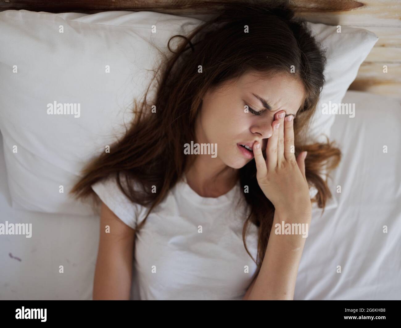 woman lying in bed with closed eyes displeased facial expression Stock ...