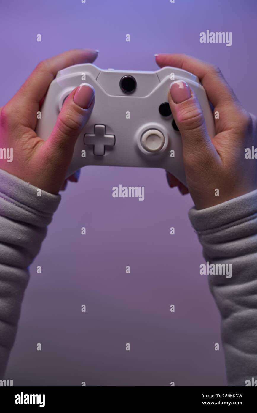 Hands with white game joystick on violet background. Gamer concept ...