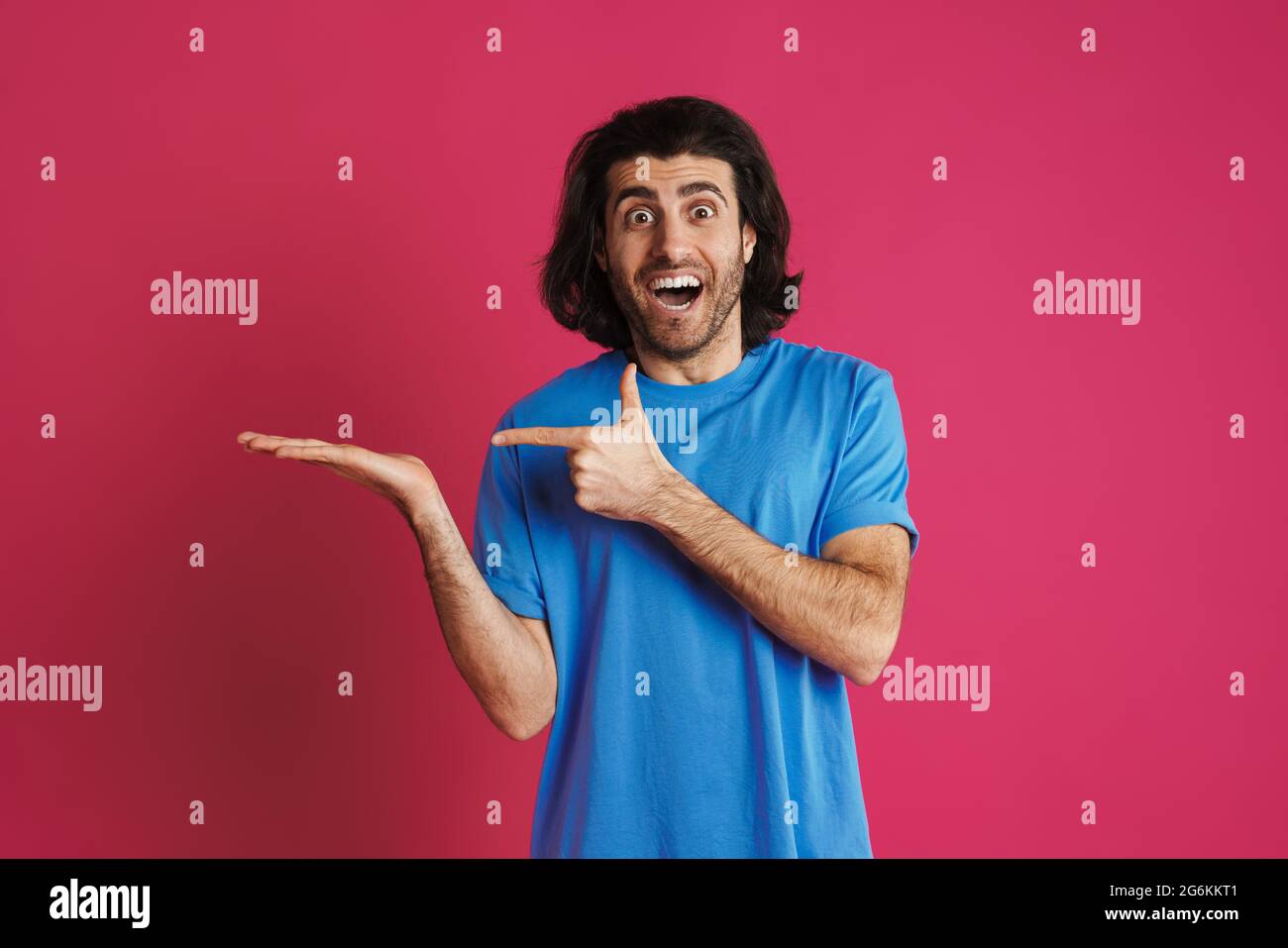 Excite brunette man holding and pointing finger at copyspace isolated ...