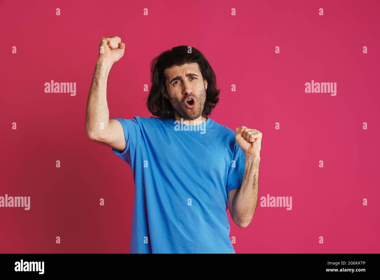 Excited brunette man screaming and making winner gesture isolated over ...