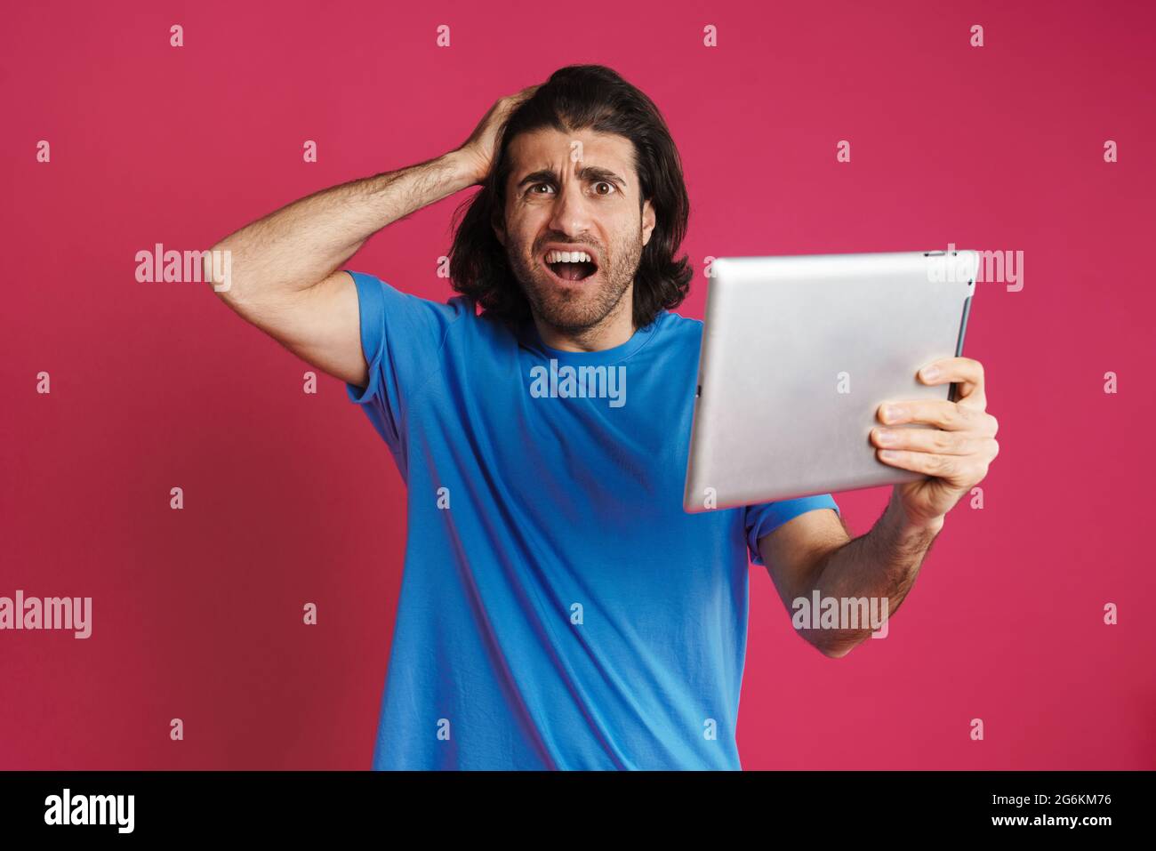 White shocked man holding his head while use tablet computer isolated ...