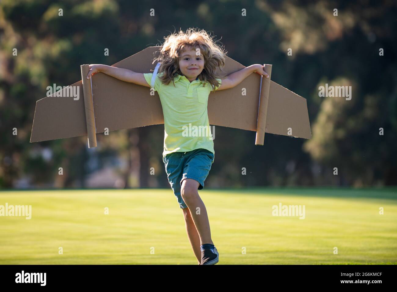 Kids fly. Funny child boy pilot flying with toy cardboard airplane ...