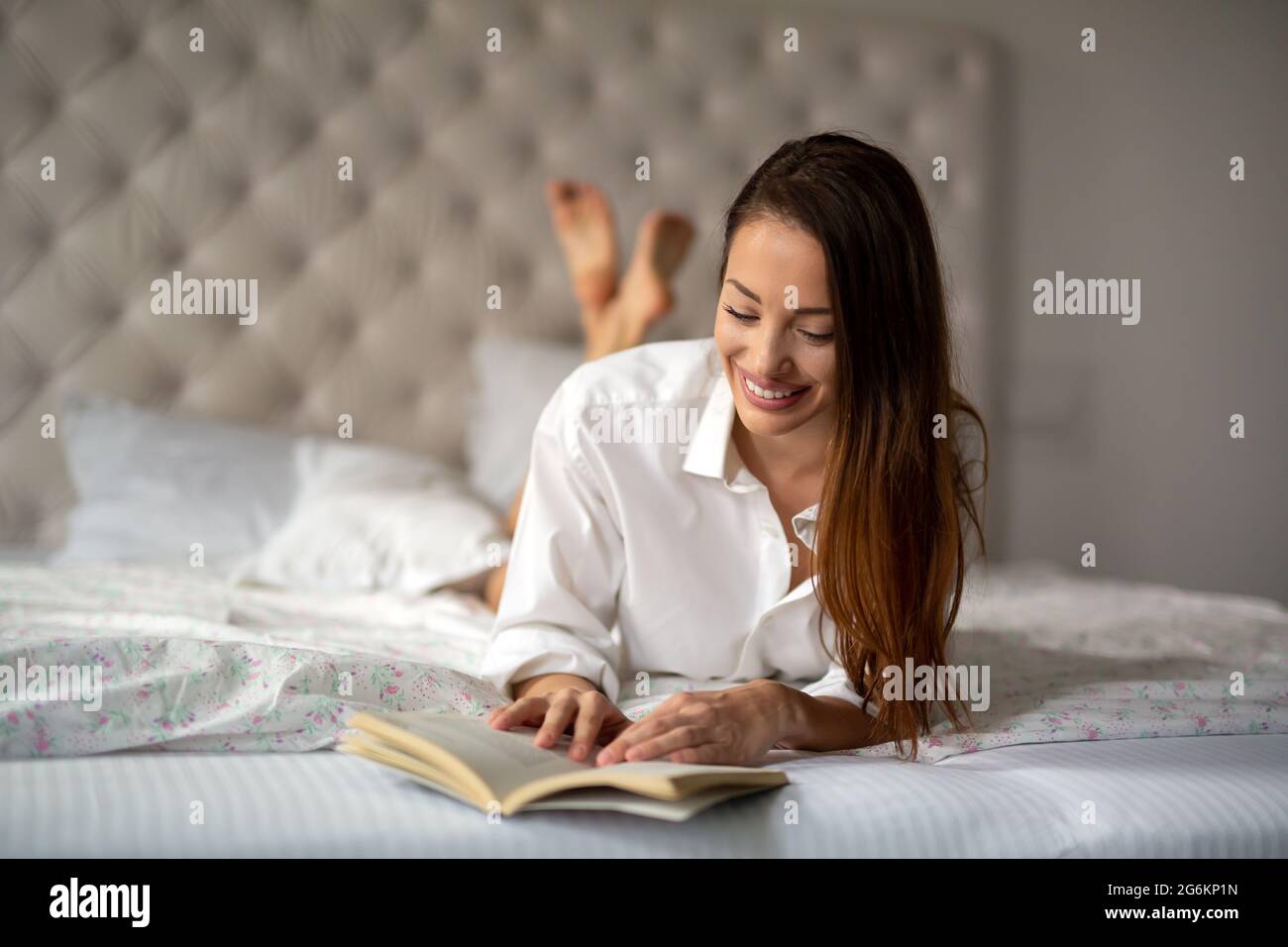 Beautiful young woman relaxing reading book at home Stock Photo - Alamy