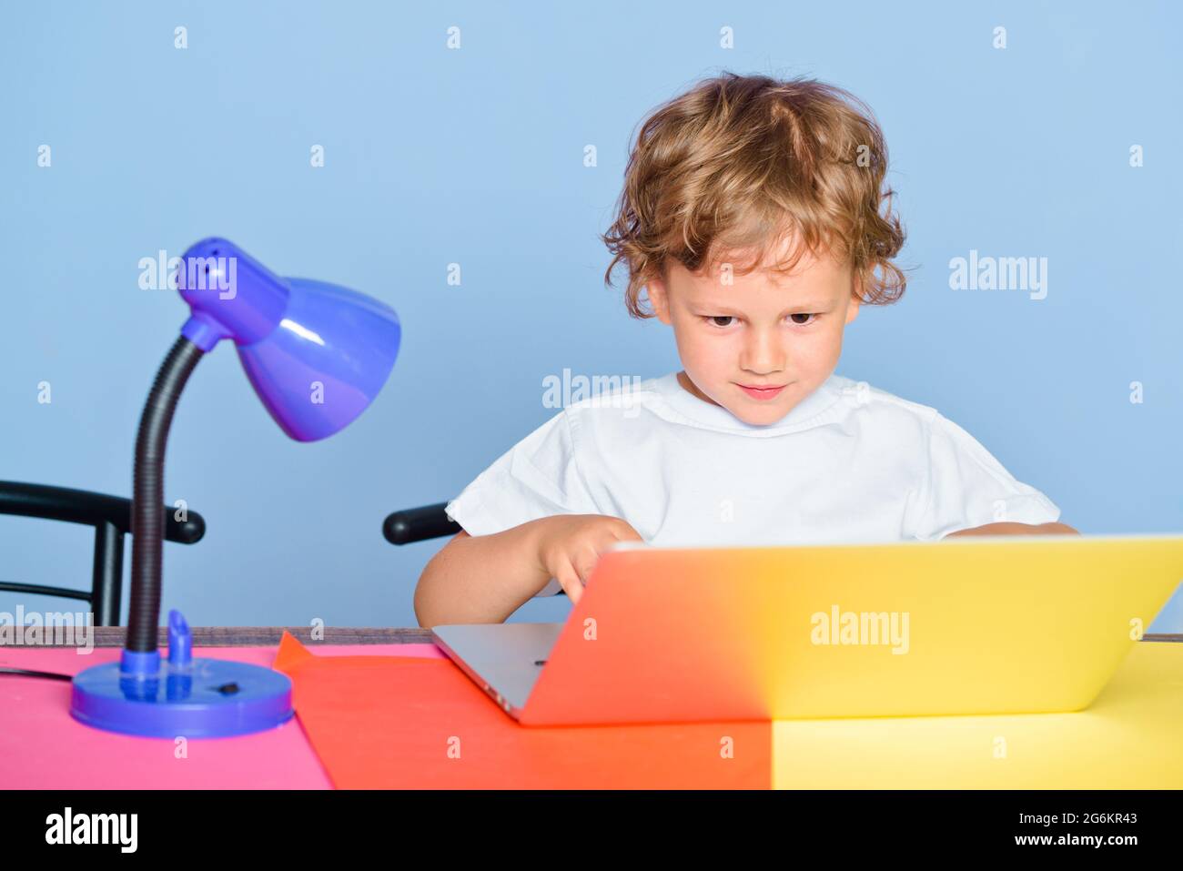 Cheerful smiling child use laptop computer. Funny little kid at school ...