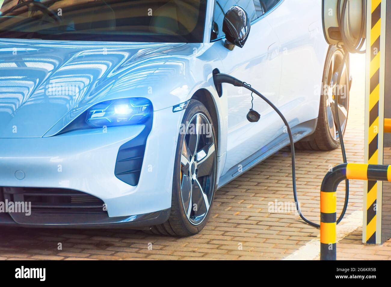 Refueling for cars e-mobility, with headlights on and blue light ...