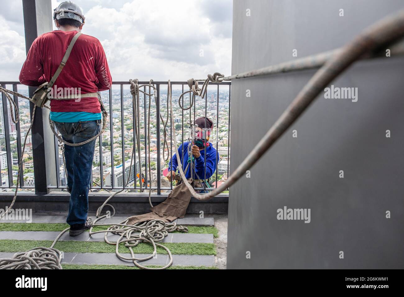 The Builder is hanging on the ropes working on high building Stock ...