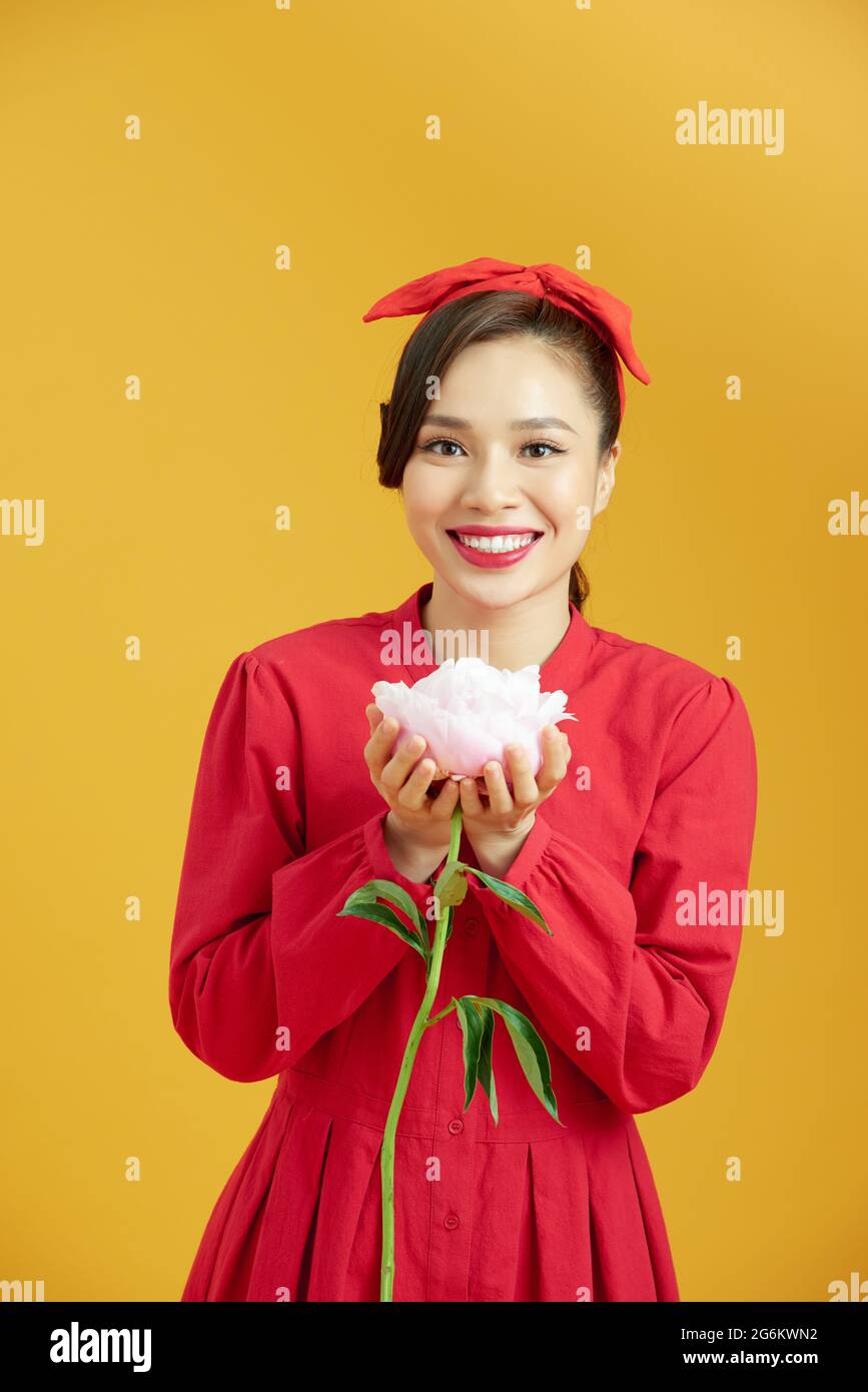 Beautiful young woman holding big pink peony Stock Photo - Alamy