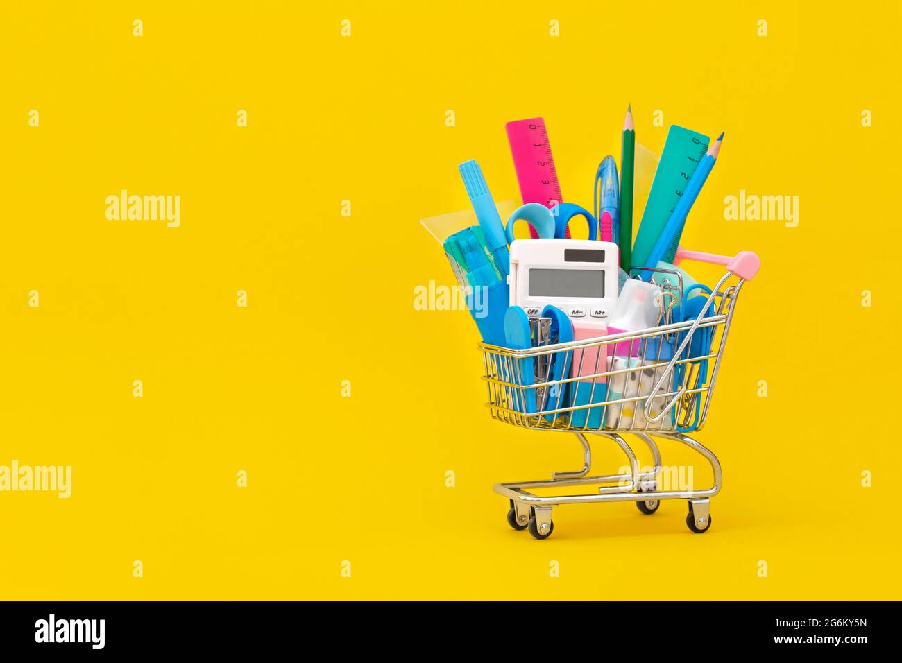 School stationery in a shopping cart on a yellow background. Back to ...
