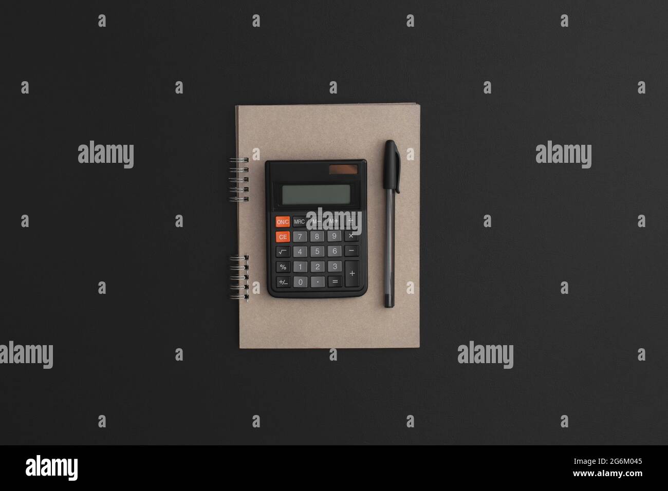 Calculator, notebook, pen on black leather background Stock Photo - Alamy