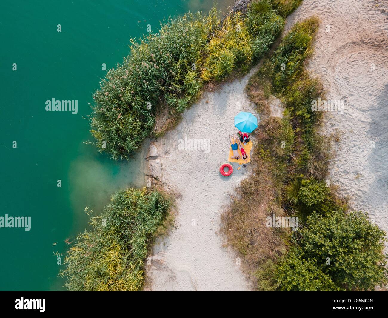 couple laying on blanket sunbathing at sandy beach blue azure water ...