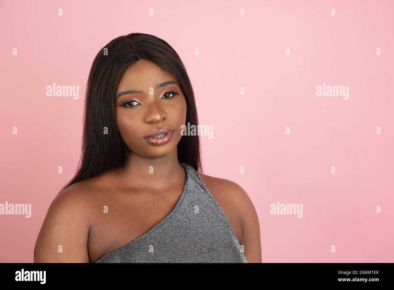 African young woman's portrait on pink studio background. Concept of ...