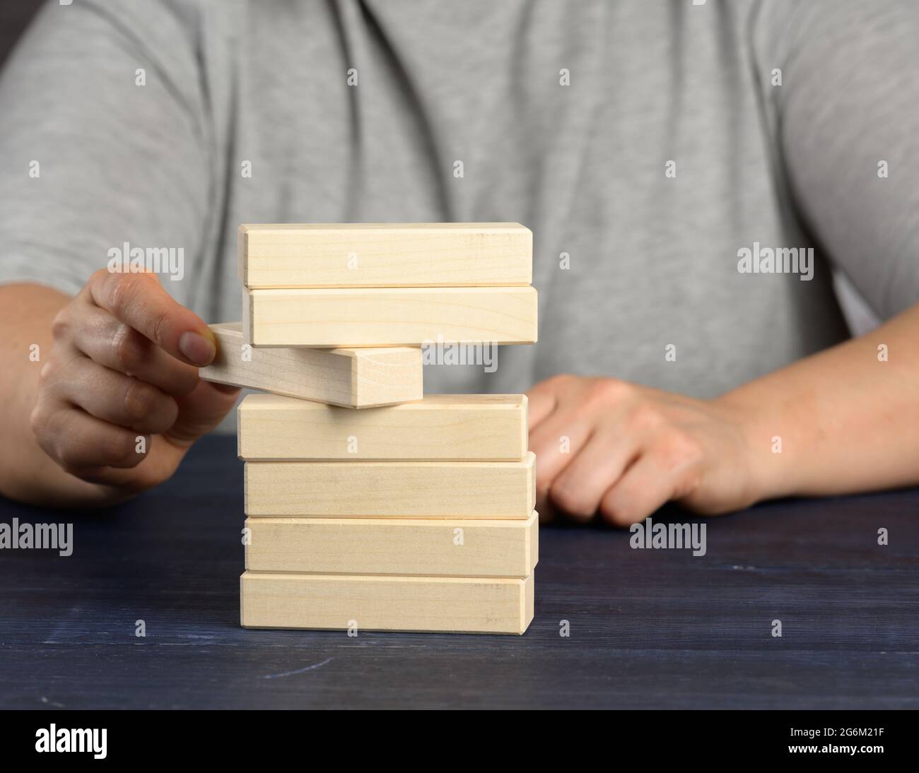 hand pulls a wooden block out of the pile. Balance concept, situation ...