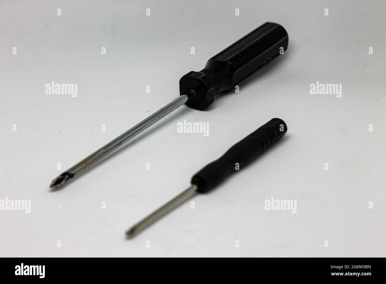 Screwdriver plus black color on a white background Stock Photo - Alamy