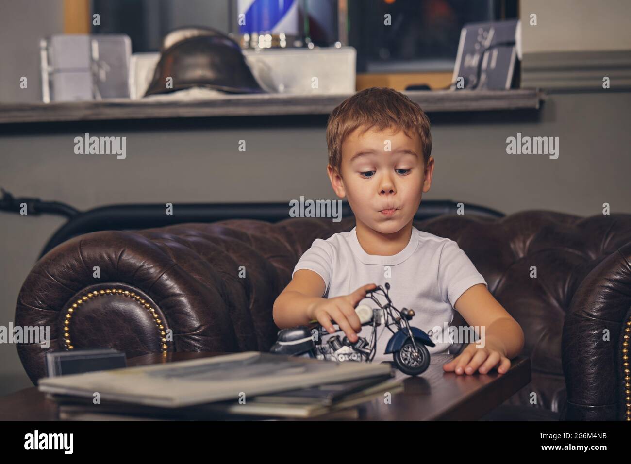 Little boy at the barbershop, in waiting room waiting for master Stock ...