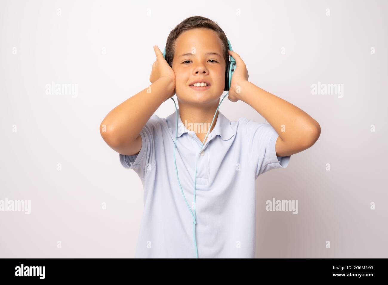 Cute smiling boy listen to the music with headphones and thumbs up ...
