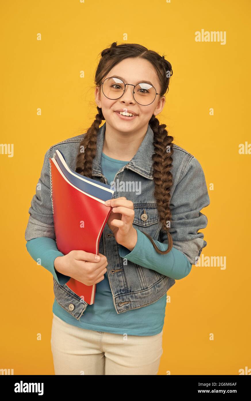 Read good books to grow. Happy child hold books yellow background ...