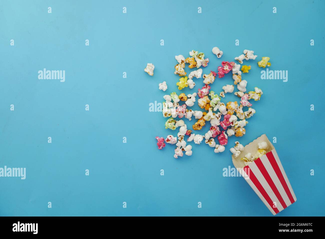 popcorn spilling from a paper container on wooden background Stock ...