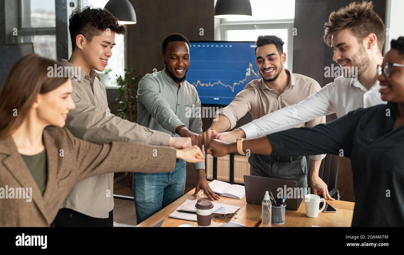 Diverse business people giving fist bump in circle at office Stock ...