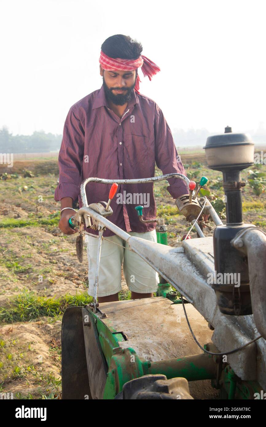 Indian Man using the power tiller to plough the fields Stock Photo - Alamy