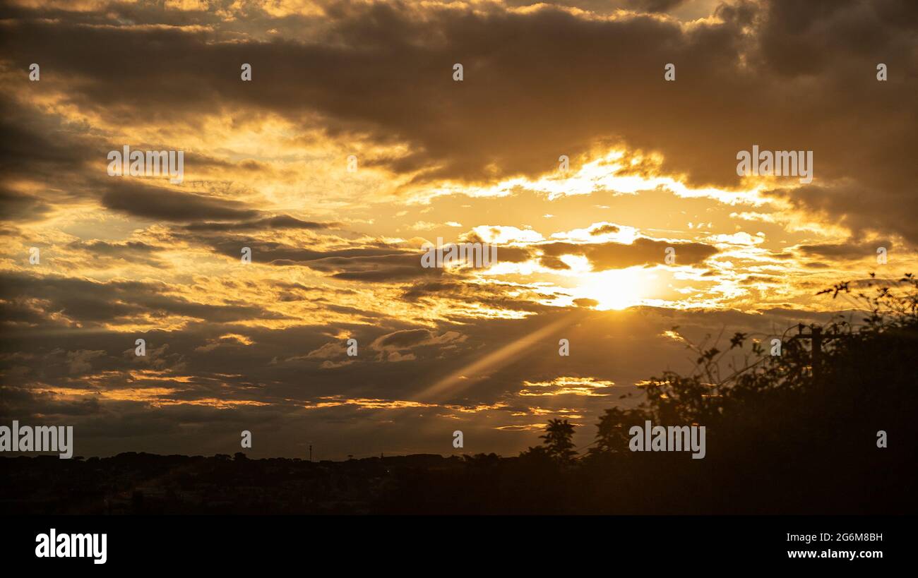 Sunset highlighted by the orange color, with dramatic clouds, below the ...
