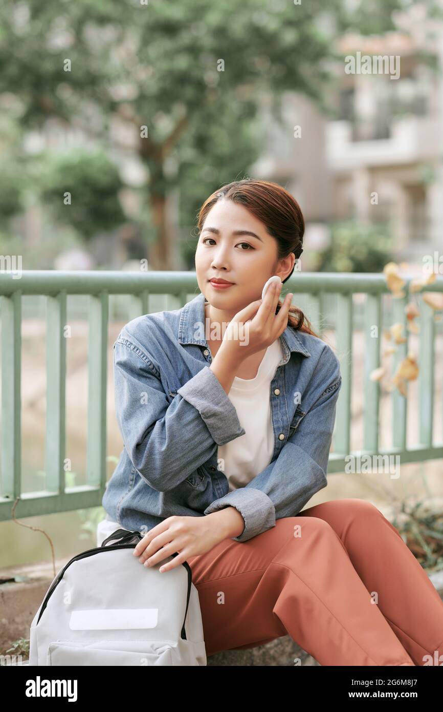 Attractive beautiful girl uses facial tissue for sweating on her face ...