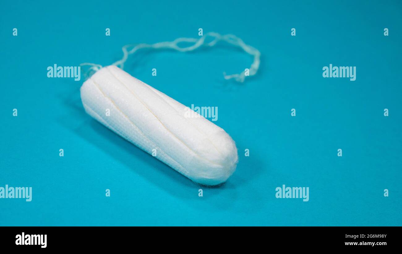 Hygienic white tampon on a blue background Stock Photo - Alamy