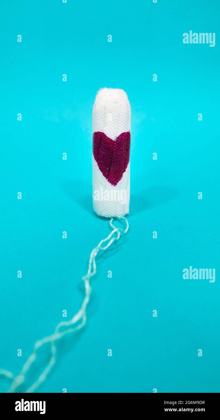 A tampon with a red heart on a blue background. Menstrual cycle and ...
