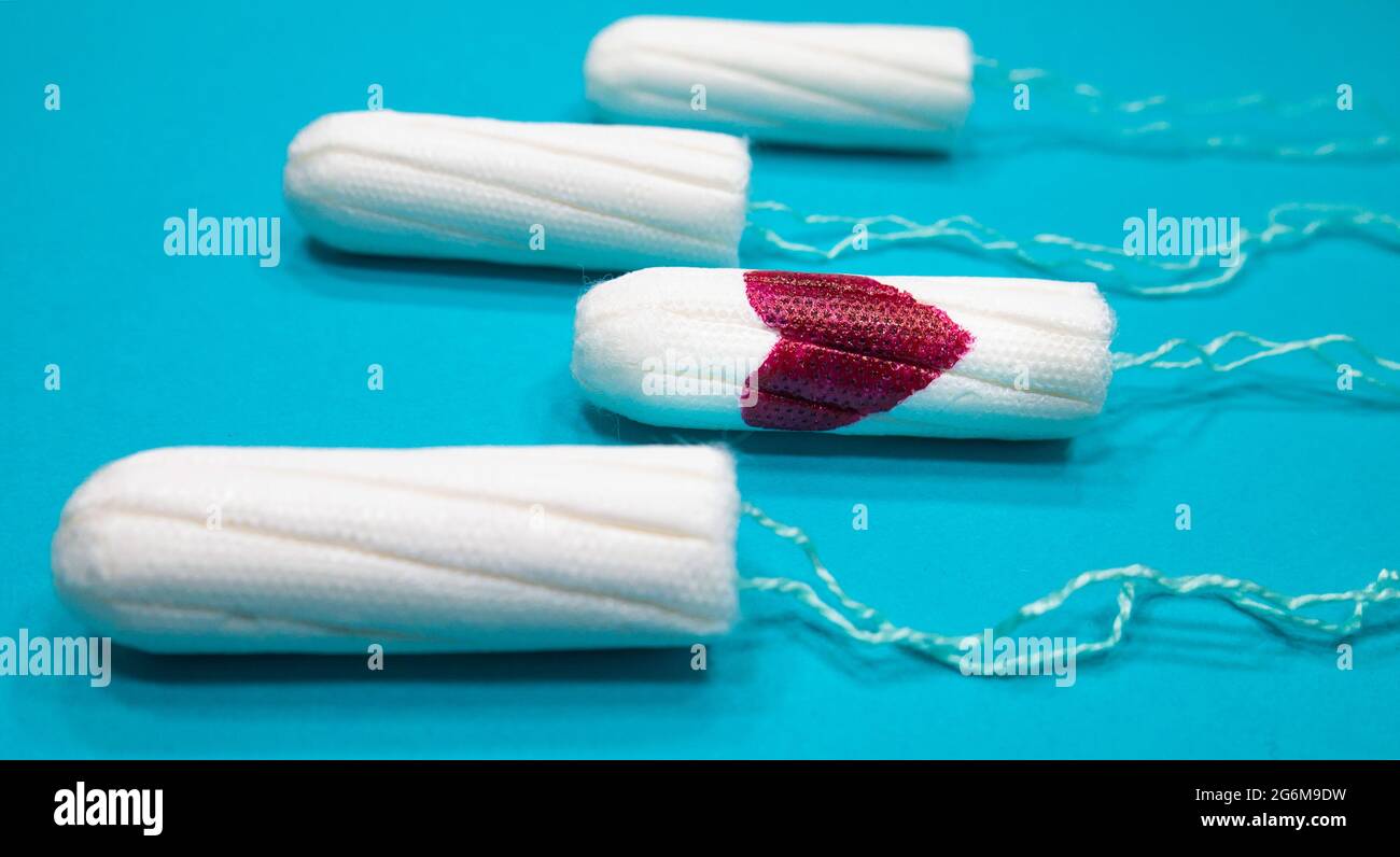 Medical female tampon on a blue background. Hygienic white tampon for ...