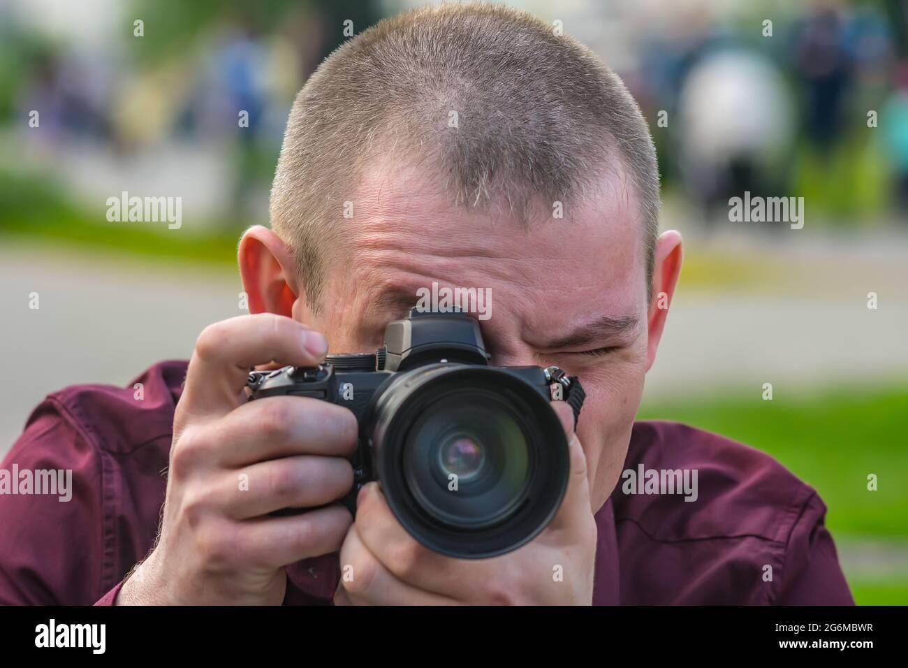 Close up portrait of photographer during the process of shooting work ...
