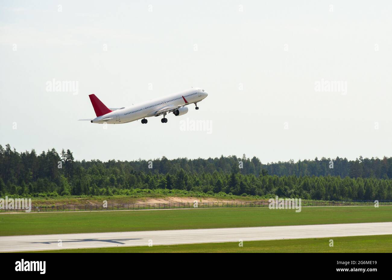 Passenger plane takes off from airport runway in forest Stock Photo - Alamy