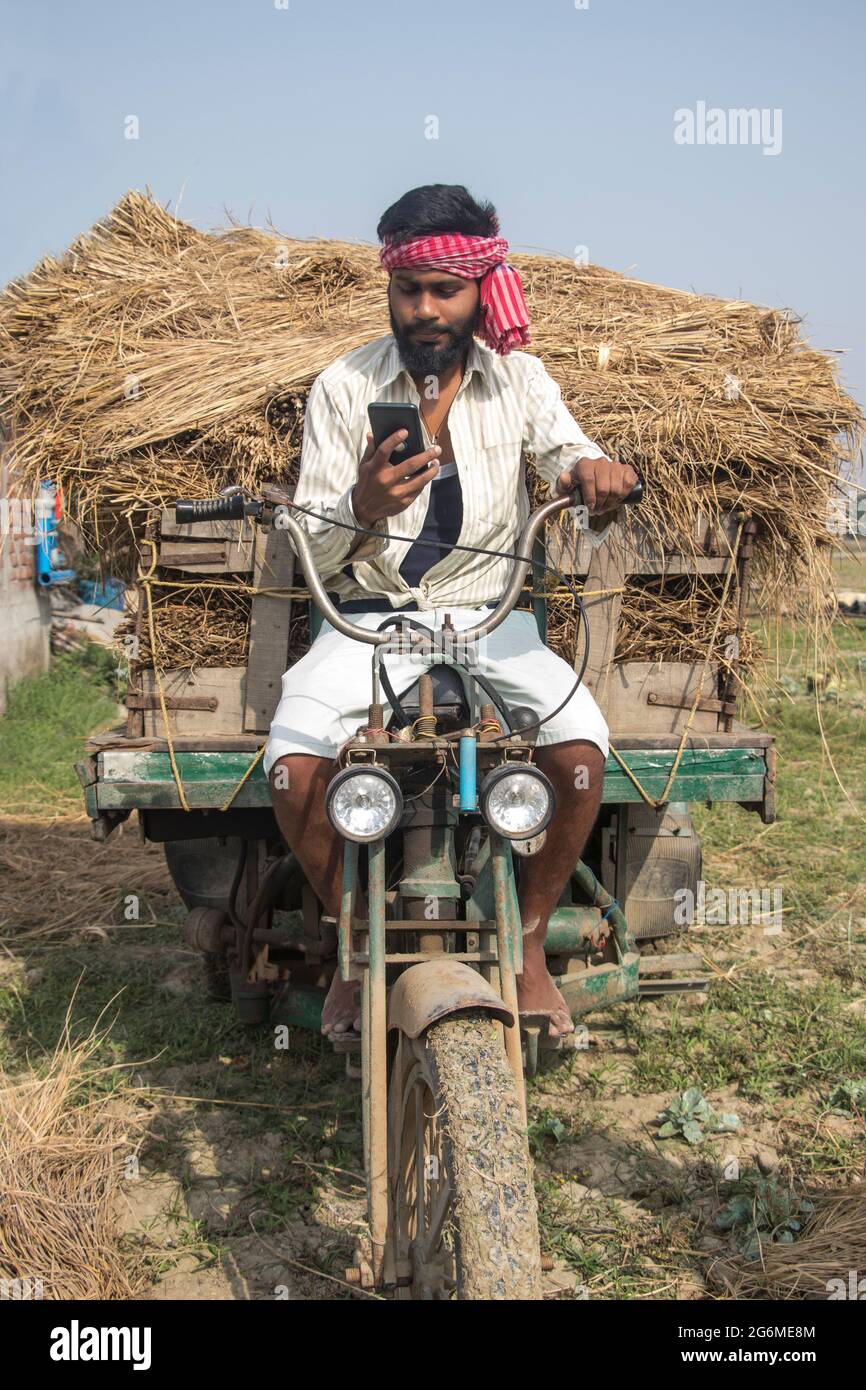Young Adult man driving machine rickshaw and using smartphone Stock ...