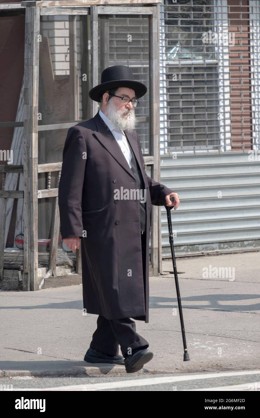 An elderly orthodox Jewish man with a cane walks on Lee Avenue. In ...