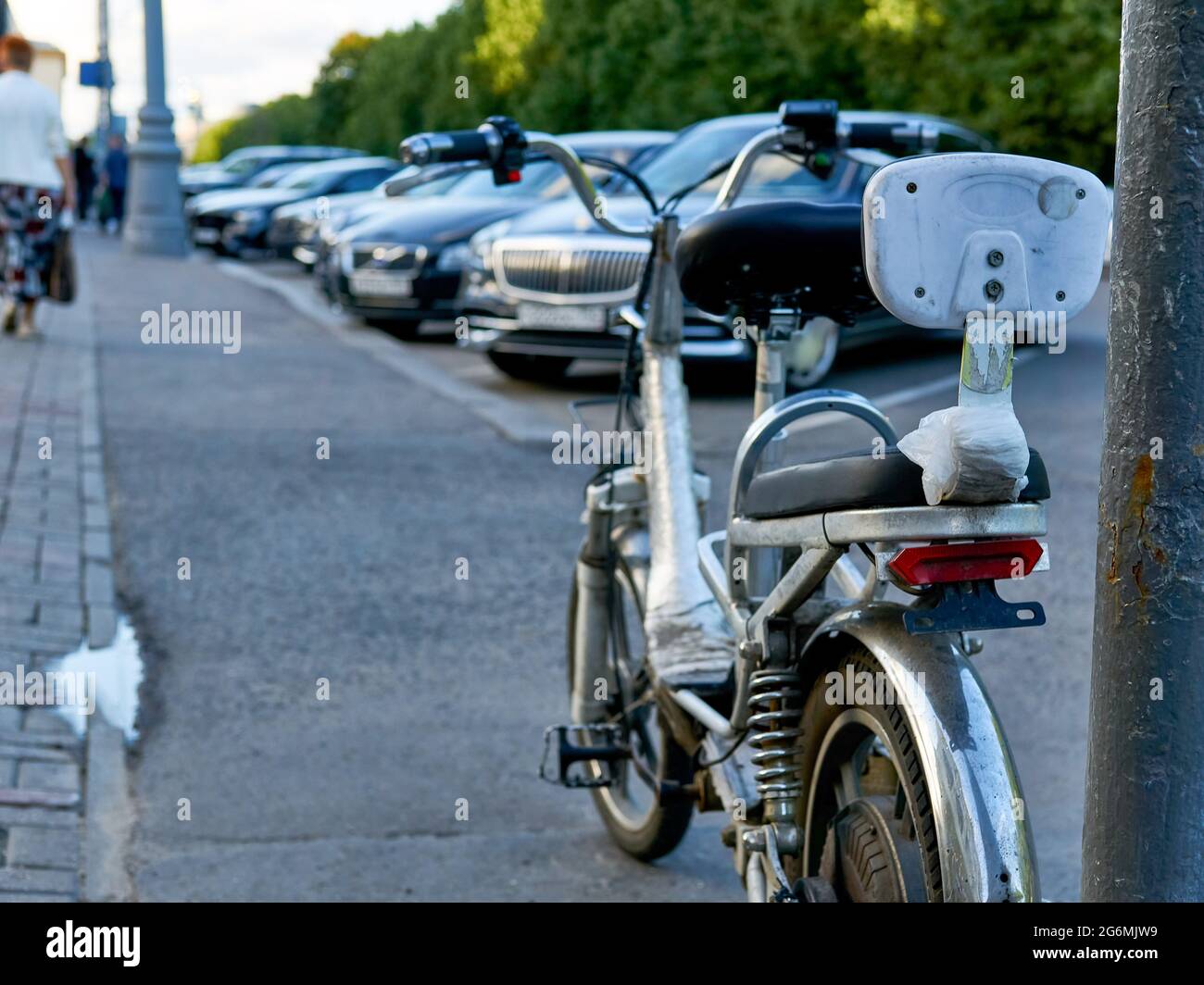 Food delivery bike in a luxury car parking lot. (Photo by Mihail ...