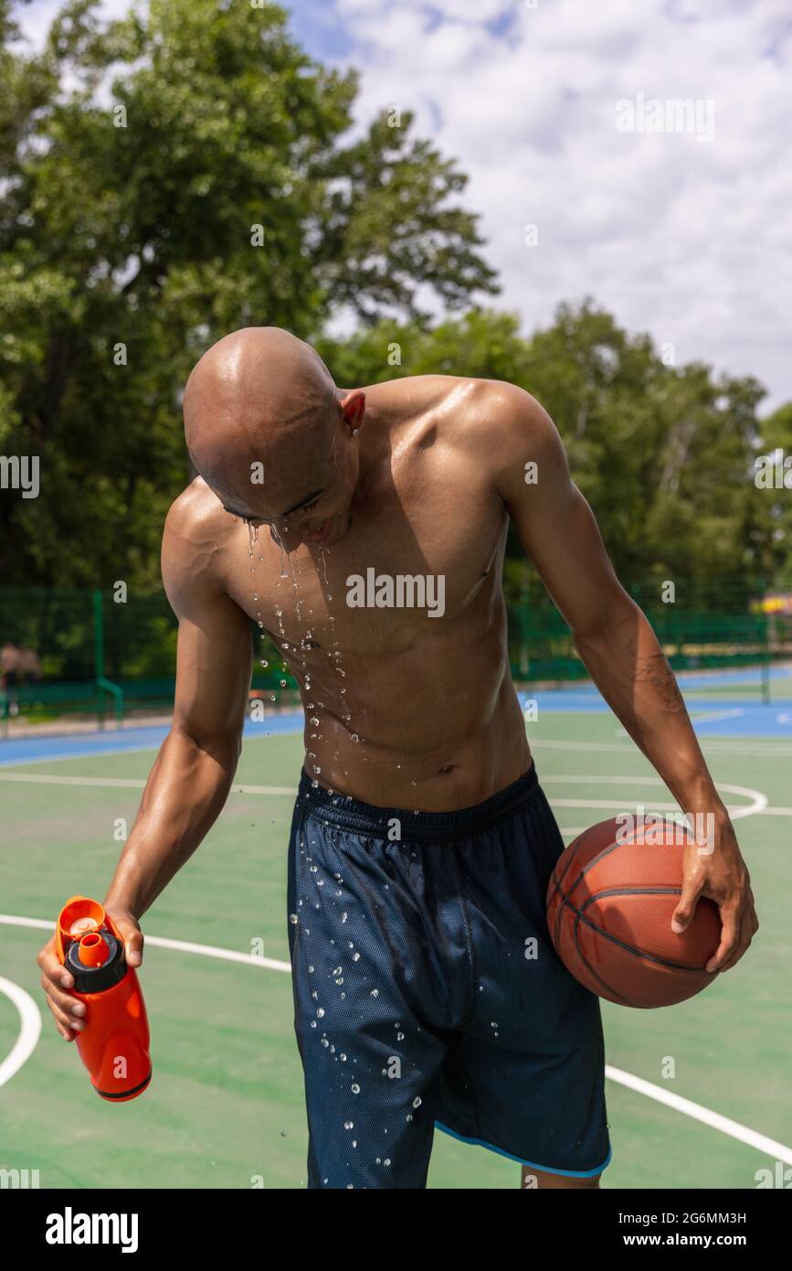 Young strong man, male basketball player training at street public ...