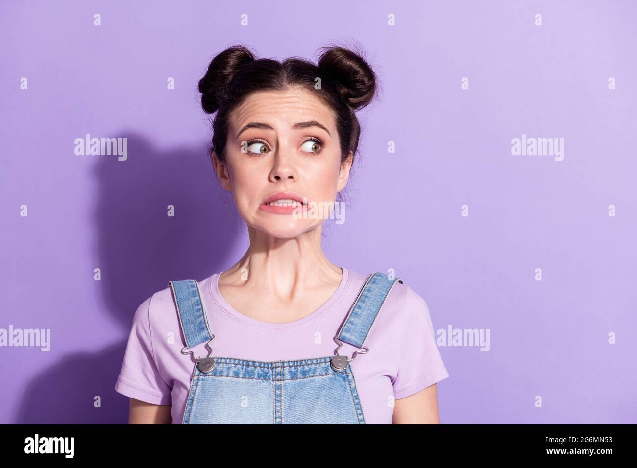Photo of impressed guilty young woman dressed denim overall looking ...