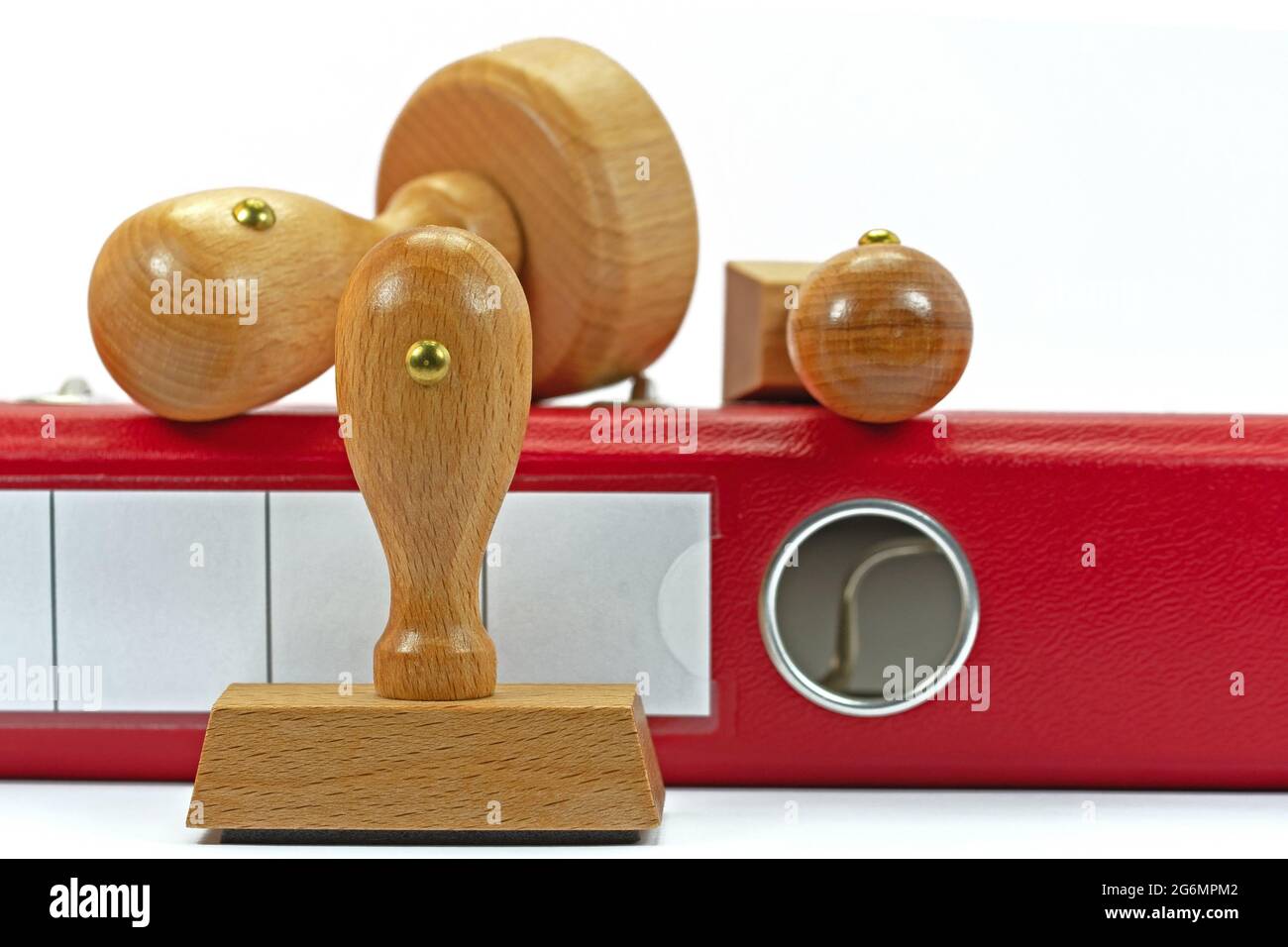 Wooden stamp and file folder against a white background Stock Photo - Alamy