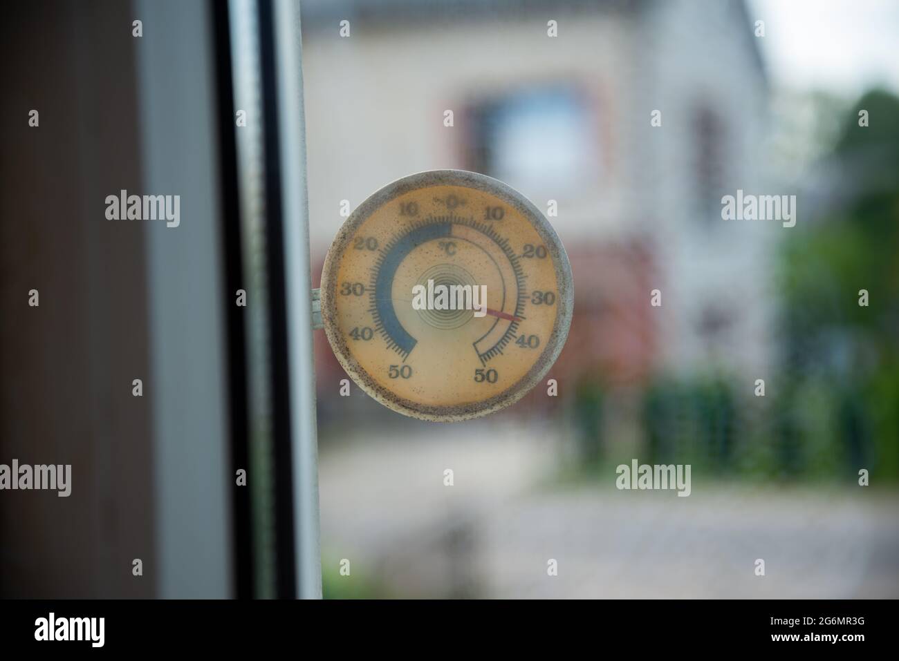 A plastic transparent square thermometer shows a high temperature of 36 ...