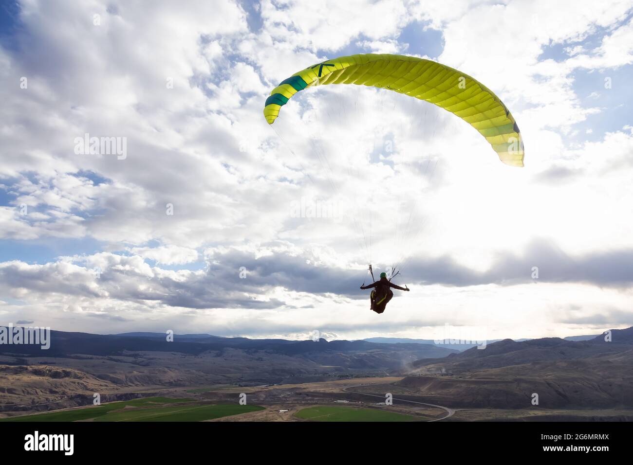 Adventurous Woman Flying on a Paraglider around the mountains Stock ...