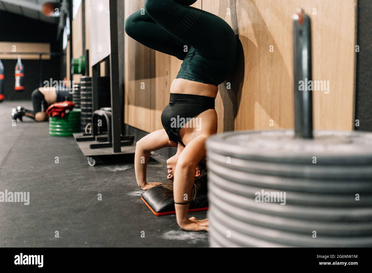 Young woman training on floor in a gym practicing handstand walk Stock ...