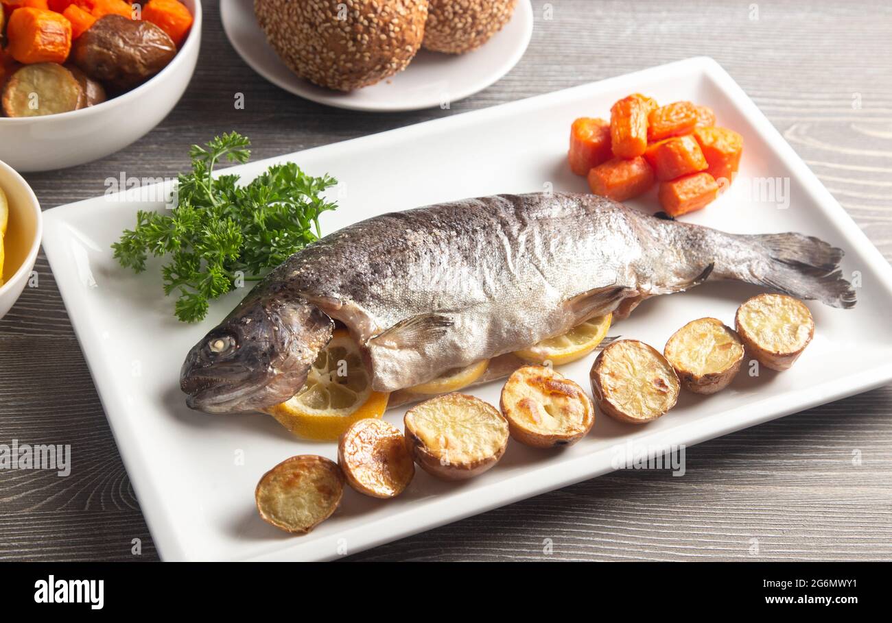 A Whole Baked Rainbow Trout on a Table Set for Dinner Stock Photo - Alamy