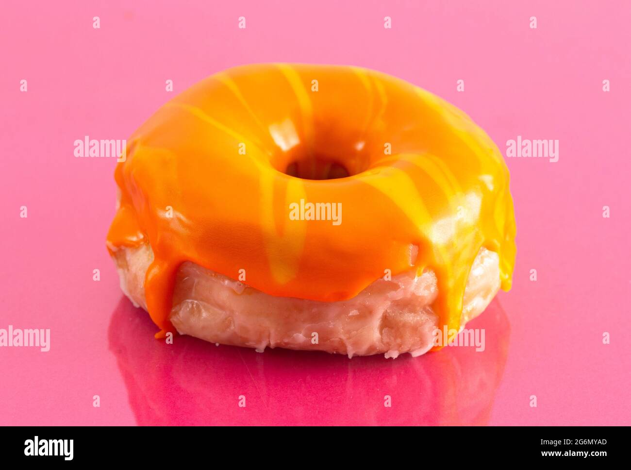 An Orange Striped Glazed Donut Stock Photo - Alamy