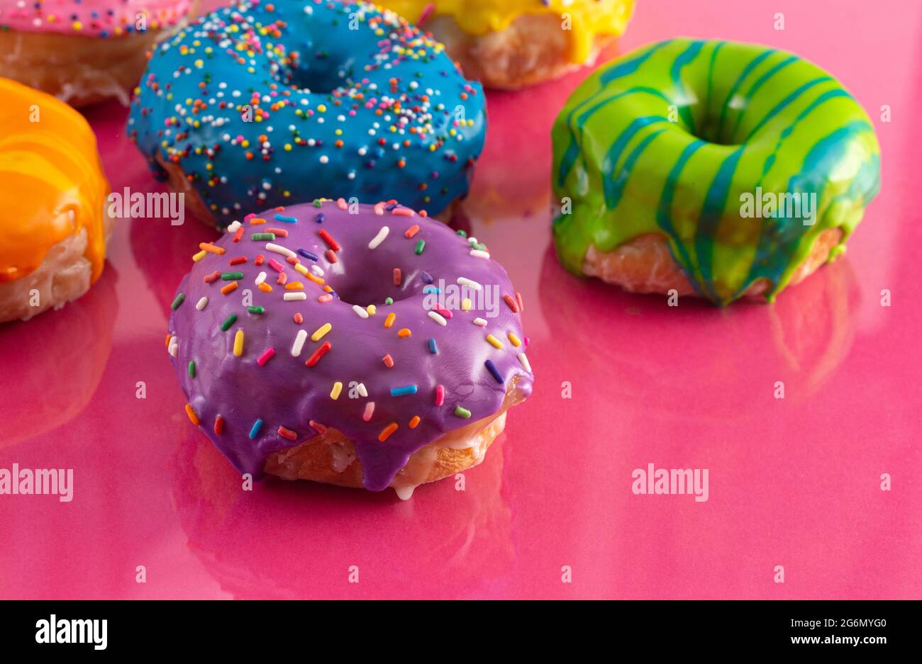 A Batch of Rainbow Colored Glazed Donuts Stock Photo - Alamy
