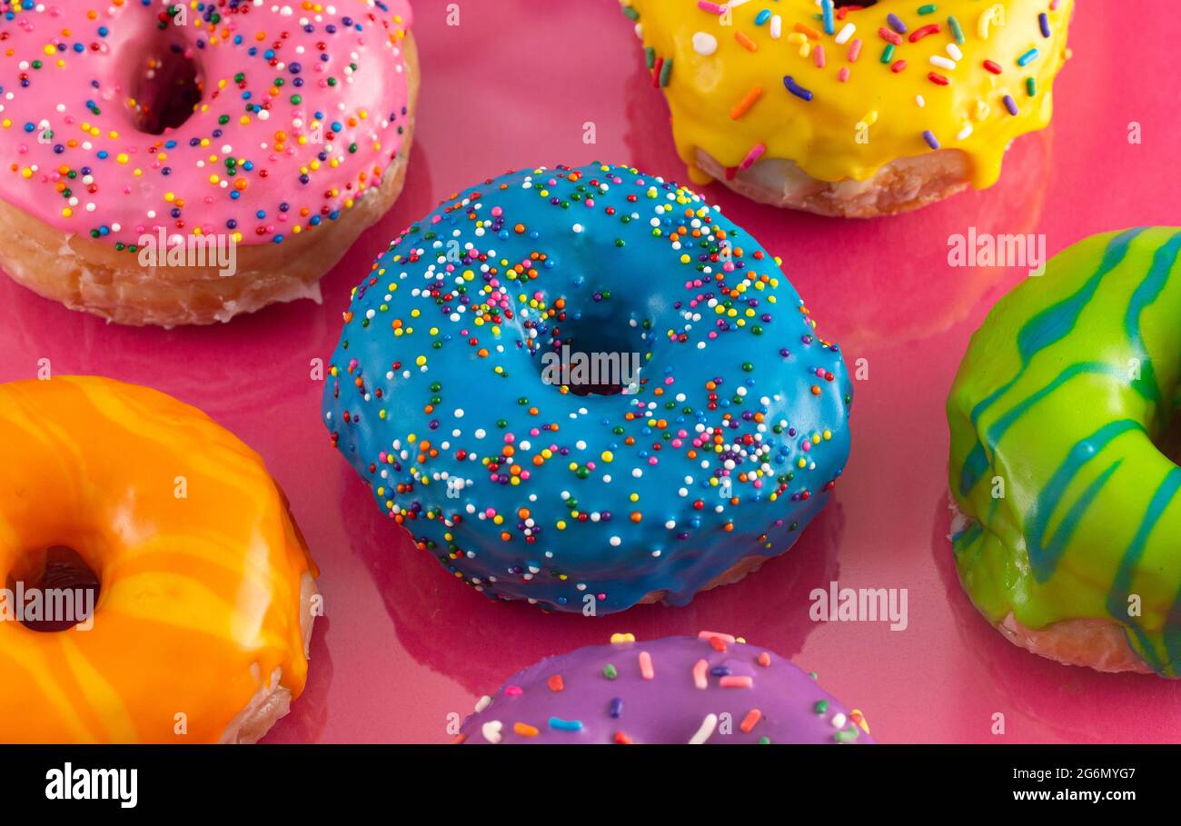 A Batch of Rainbow Colored Glazed Donuts Stock Photo - Alamy