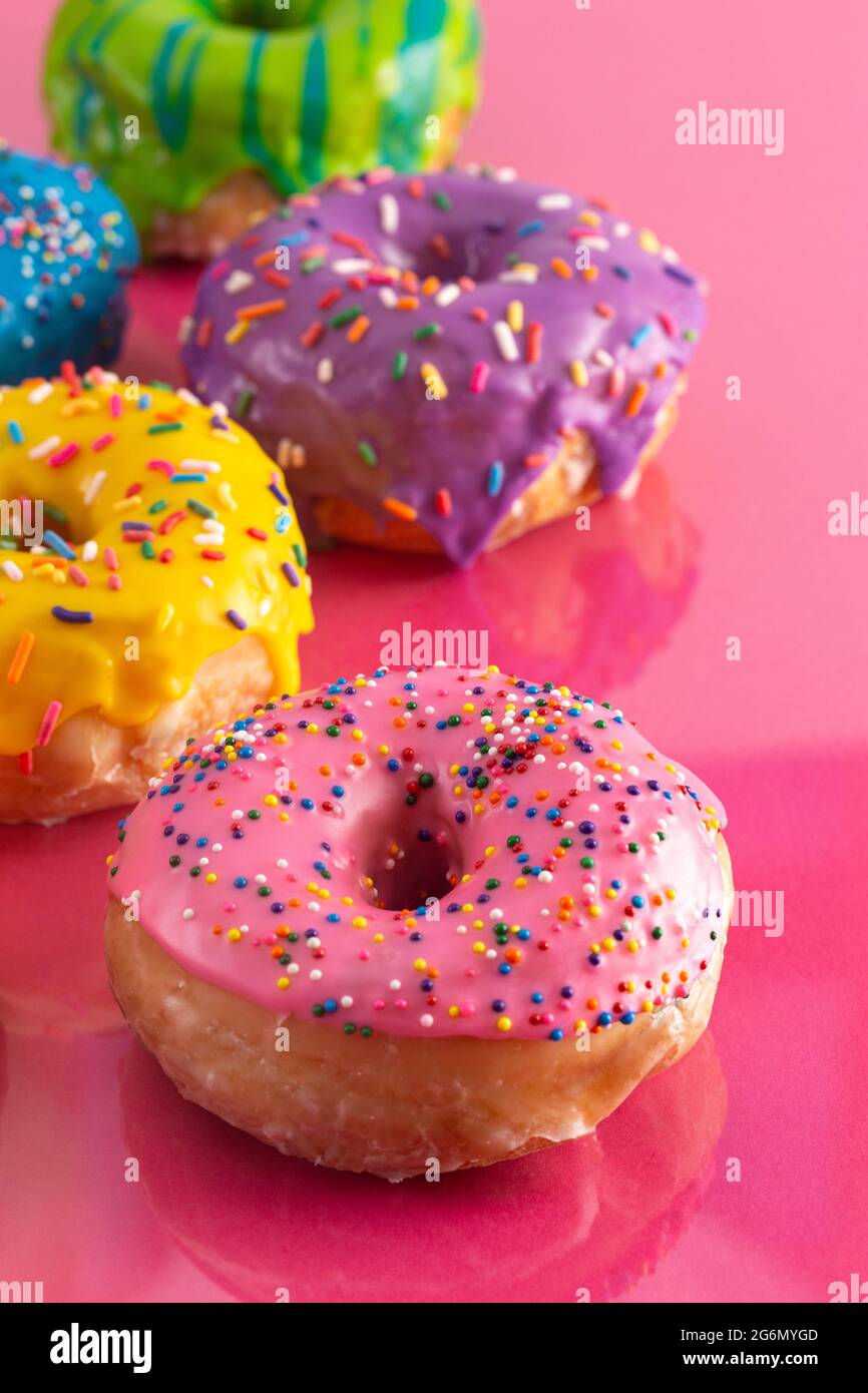 A Batch of Rainbow Colored Glazed Donuts Stock Photo - Alamy