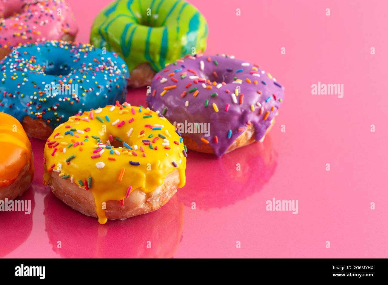 A Batch of Rainbow Colored Glazed Donuts Stock Photo - Alamy