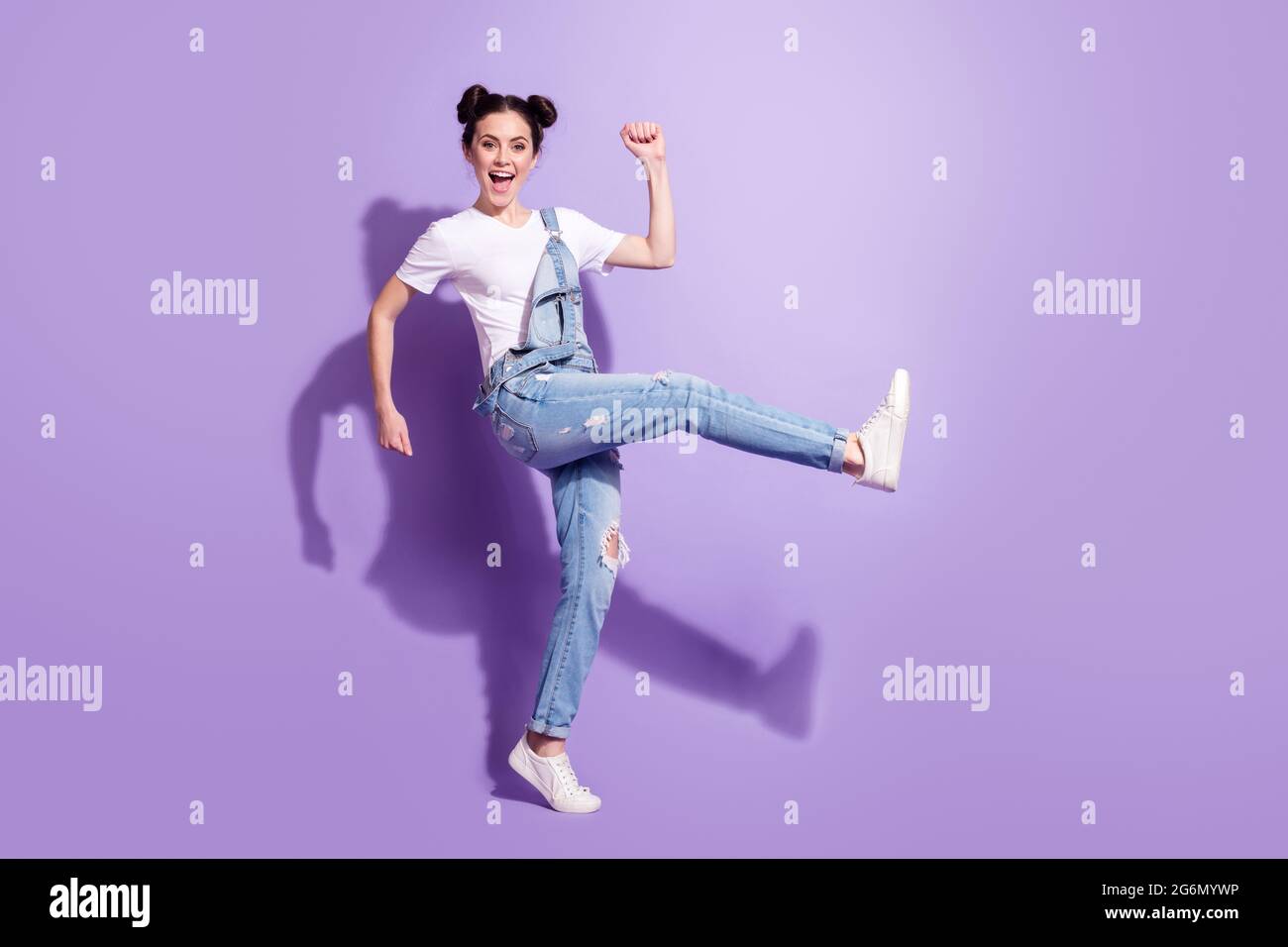 Photo of adorable funky young woman dressed denim overall walking ...